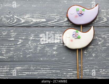 Violet and white romantic cookies on a gray wooden background with copy ...