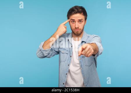 Portrait of idiot man in denim shirt making silly humorous face with ...