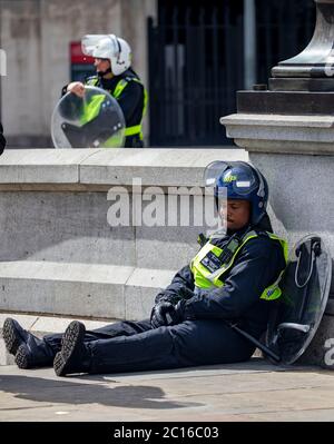 pic shows: Constable Black Exhausted riot cop takes a breather after ...