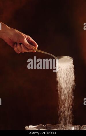 photo of hand pouring sugar into bowl Stock Photo - Alamy