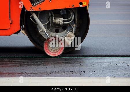 Heavy compactor tires the upper layer of asphalt in the construction of ...