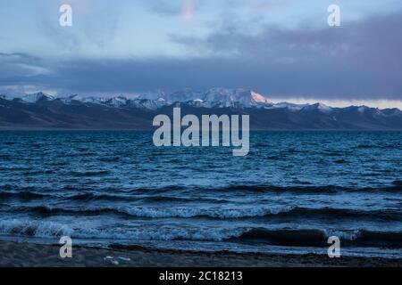 The Nyenchen Tangula mountain range seen across Nam lake at sunset ...