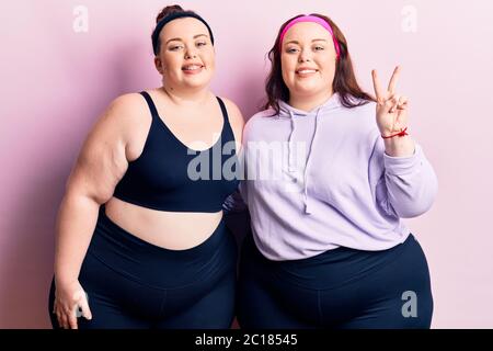 Two plus size overweight sisters twins women hugging together outdoors ...