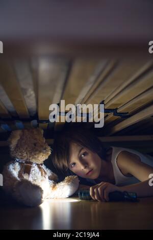 Sad little boy hiding under slide on children playground at ...