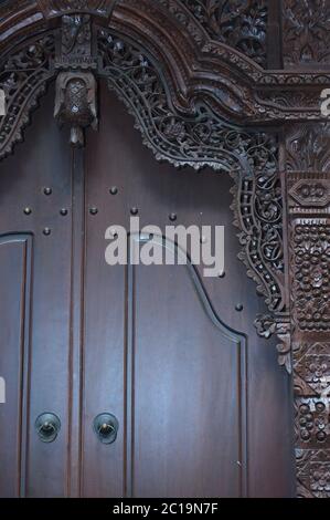 facade of a traditional Javanese wooden house framed by a concrete gate ...
