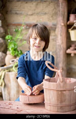 Child, cute boy, making ceramic pot on a farm Stock Photo - Alamy