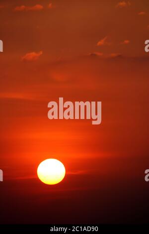 Impressive clouds of red and orange colors during sunrise on the beach ...