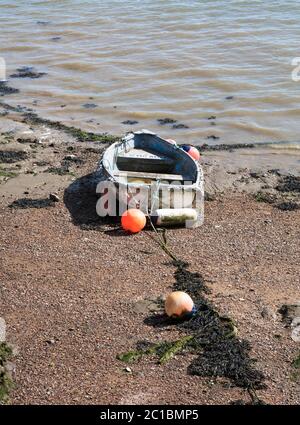 An abandoned boat with oars on the shore of a lake Stock Photo - Alamy