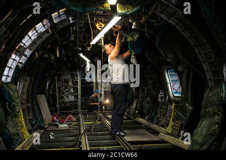 Plane overhauling. Electrician installing new electrical wiring inside ...