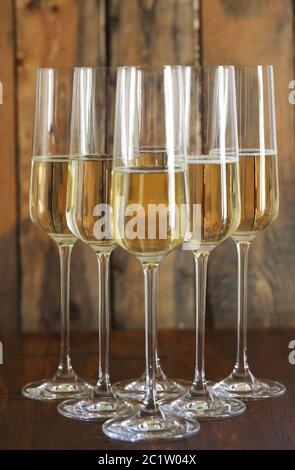Set of champagne glasses on wooden table with candles against blurred ...