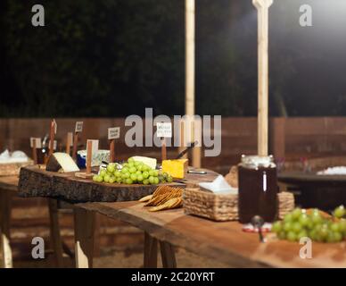 Rustic cheese board with a selection of labelled cheeses and cured ...