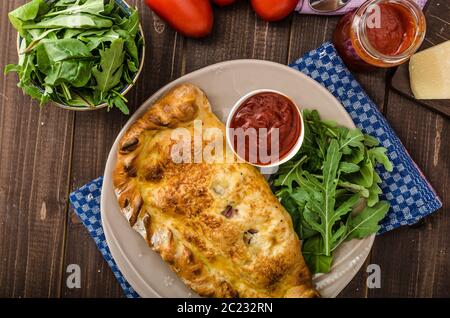 Calzone pizza stuffed with cheese and prosciutto, hot dip and summer ...