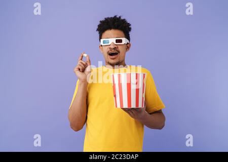 Photo of scared young man watching in stupor crazy horror movie sipping ...