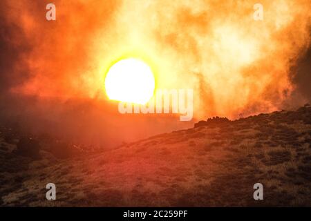 Sun seen through thick smoke in the sky caused by a wildfire in ...