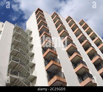 Angled detail view of an old 1960s white concrete apartment building ...