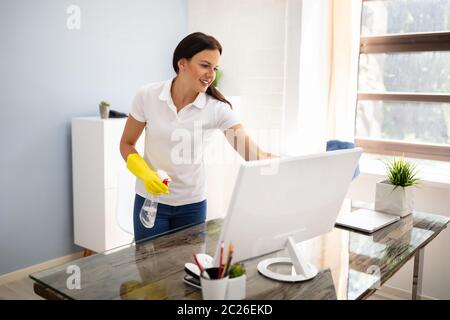 Young Woman Cleaning Computer With Blue Napkin In Office Stock Photo ...