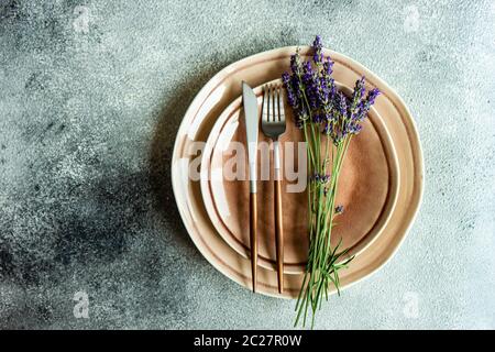 Beautiful table setting and lavender flowers in light room interior ...