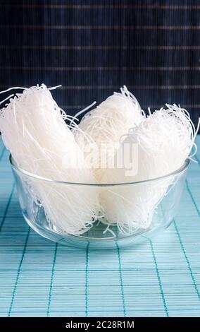 Plate with raw rice noodles and chopsticks on white background Stock ...