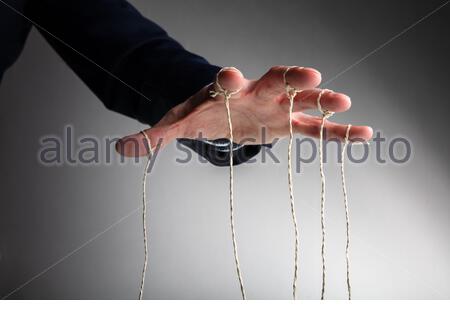 Manipulation concept. Puppet master hands controlling the stock market ...