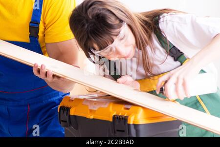 Man explaining woman woodworking tips in wood workshop Stock Photo - Alamy