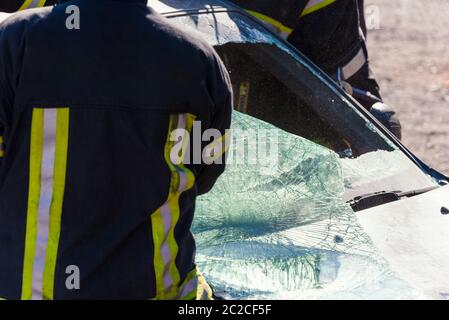 Firefighters, fireman cut a car glass in car accident Stock Photo - Alamy