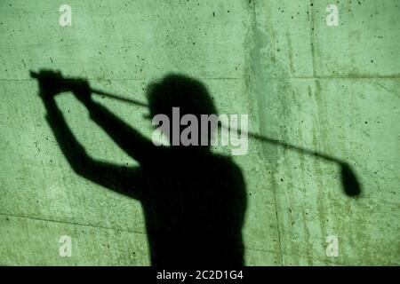Shadow of a Golfer on a Wall Holding a Golf Club Stock Photo - Alamy