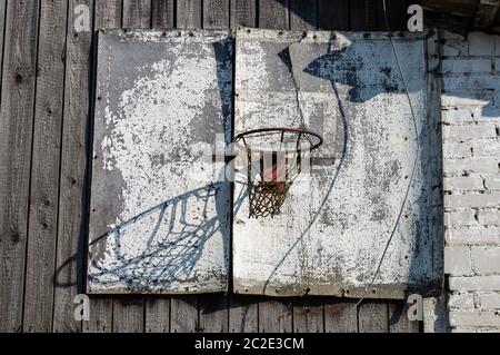 Old abandoned basketball court with a broken basket. The backboard is ...