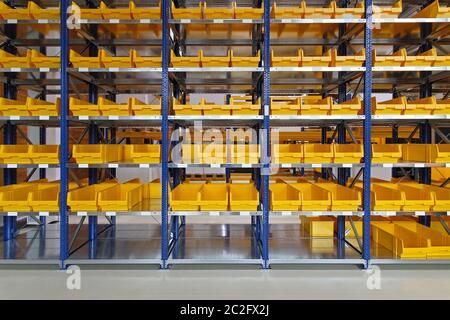 Yellow plastic bin trays at shelf in warehouse Stock Photo - Alamy