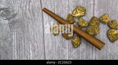 Several bright green medical marijuana buds on a wooden surface with a ...