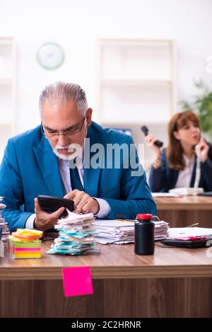 Two employees and excessive work in the office Stock Photo - Alamy