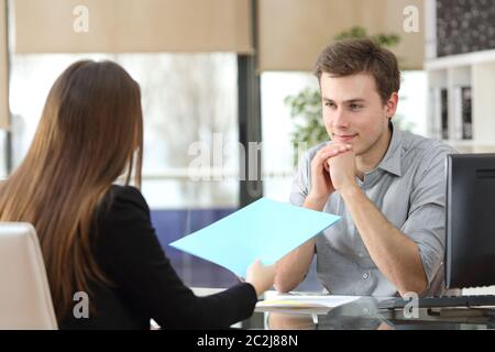 Two attentive businesspeople talking and sharing report at office Stock ...
