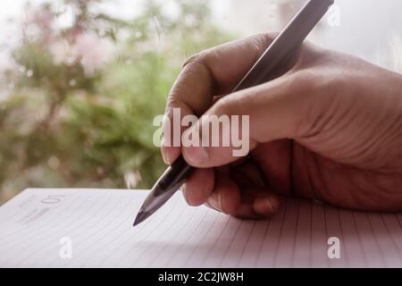 Closeup view of businesswoman filling data in a table printed on white ...
