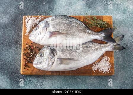 Fresh dorada with seasonings on the wooden board Stock Photo - Alamy