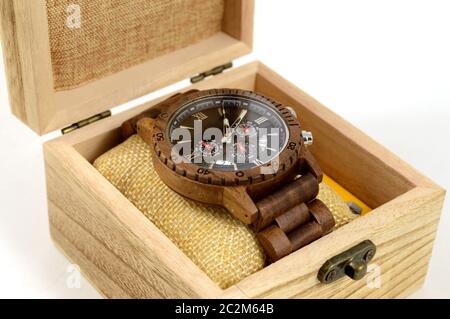 A closeup of a beautiful walnut wood watch on a dark green background ...