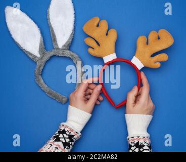 Top view of reindeer in female hands on blue background. Christmas ...