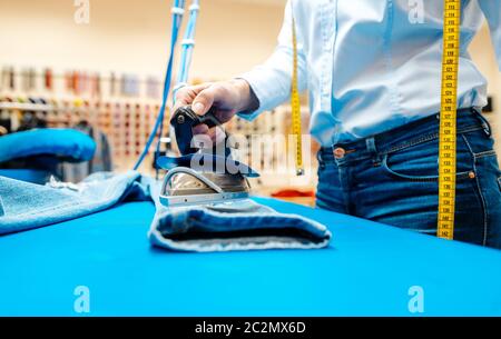Employee in textile cleaning ironing some trousers, close-up Stock ...