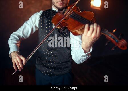 Portrait of male fiddler playing classical music on violin. Violinist ...