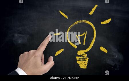 Hand pointing on lightbulb concept Stock Photo - Alamy