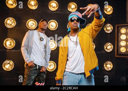 Black rappers in caps on stage with spotlights Stock Photo - Alamy