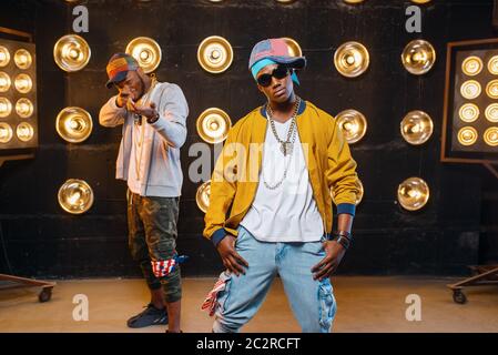 Black rappers in caps on stage with spotlights Stock Photo - Alamy