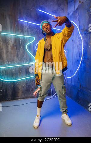 Black rapper in underpass neon light on background. Rap performer in ...