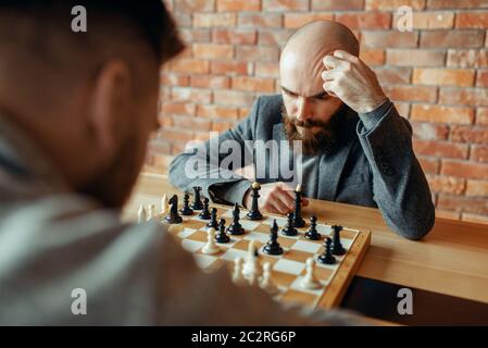 Male chess players begin playing, the first move Stock Photo - Alamy