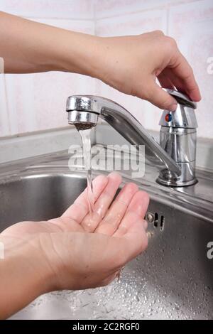 A hand opening a water tap Stock Photo - Alamy