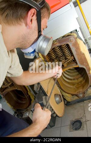 Repair man servicing big gas boiler Stock Photo - Alamy