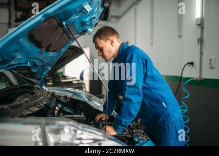 Mechanic makes visual inspection of the car engine, motor diagnostic ...