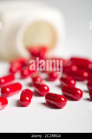 Pills spilling from an open bottle isolated on pink background Stock ...