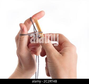 Female hands are looping the first row of knit. Deft fingers are ...