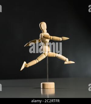 Human wood manikin is jumping against dark background Stock Photo - Alamy