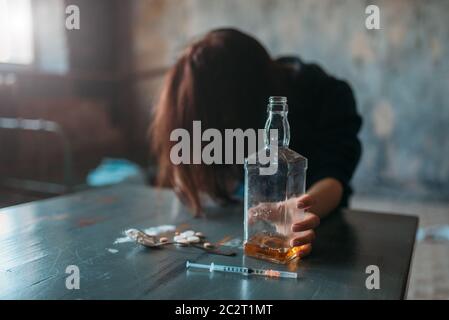 Female junkie with drugs and alcohol at table on white background Stock ...
