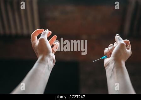 Female junkie hands with syringe, grunge room interior on background ...
